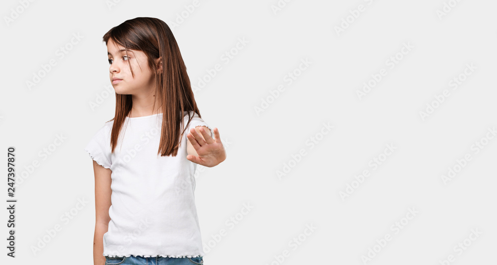 Full body little girl serious and determined, putting hand in front ...
