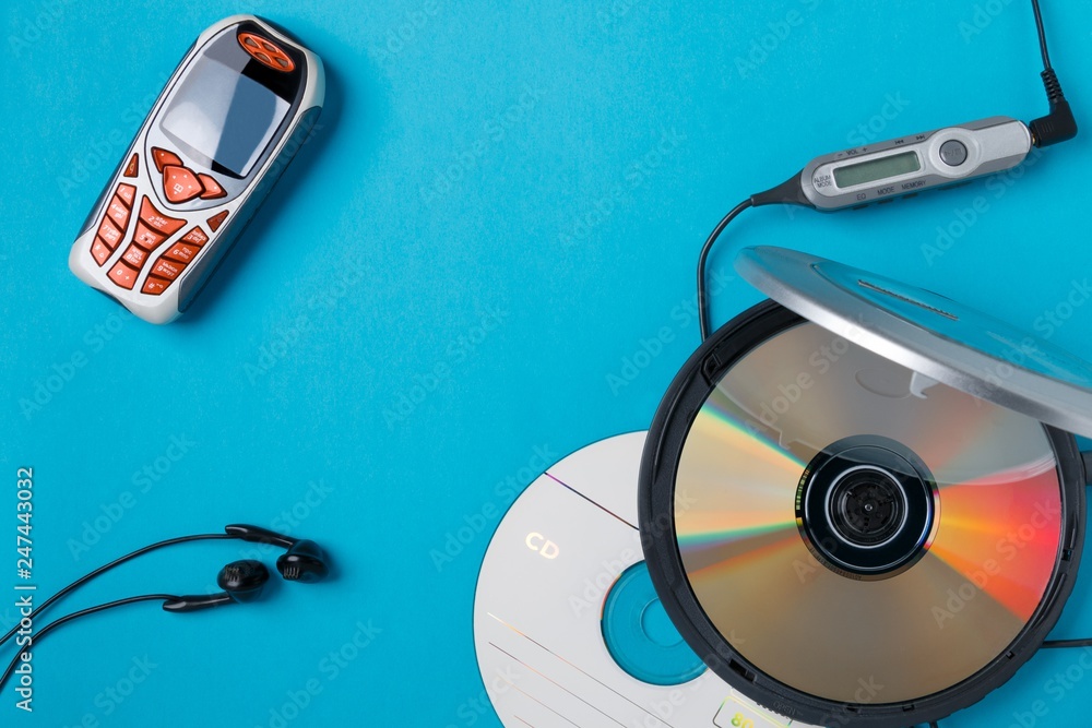 personal cd player with remote control and mobile phone on blue ...