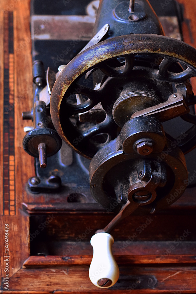 Partial side view of the white handle and the turning wheel of an old ...
