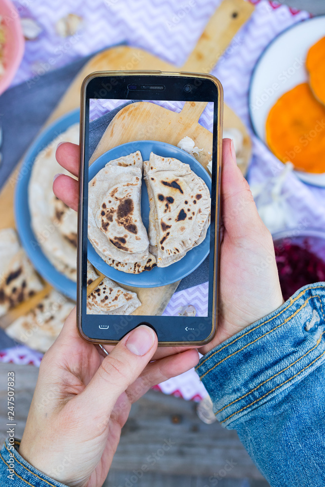 Smartphone food photography. Woman hands holds phone and take photo of ...