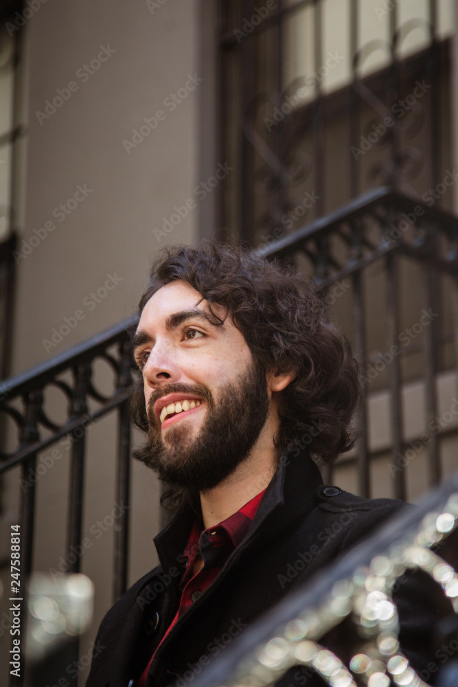LGBT Chilean Man with beard sits on urban New York City stoop Stock ...