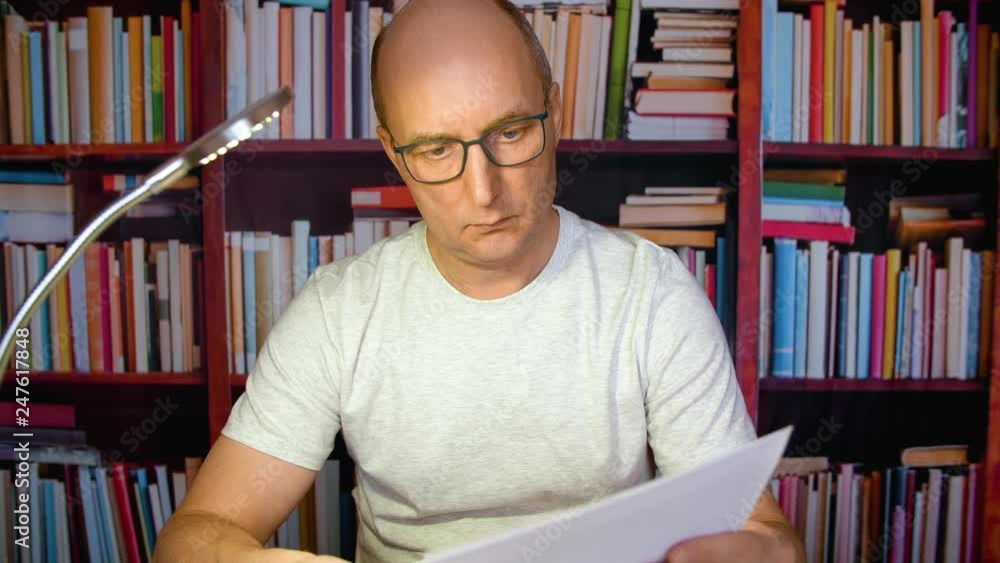 Man reading paper documents. Attentive man reading paper documents ...