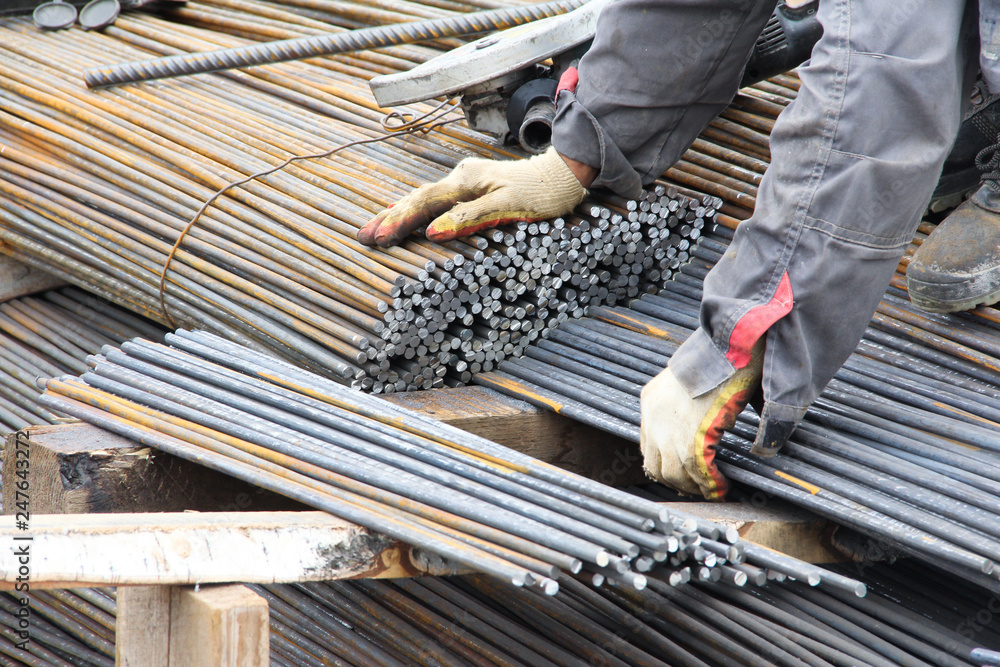 Worker makes blanks from rebar. Production of parts for concrete work ...