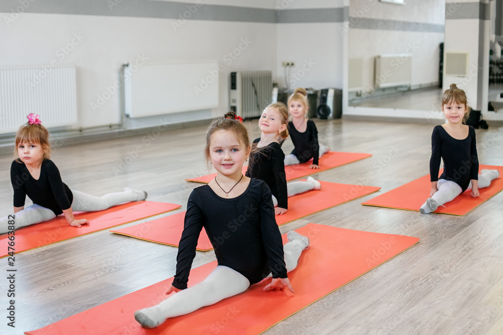 A group of little girls doing splits in training. The concept of sport ...
