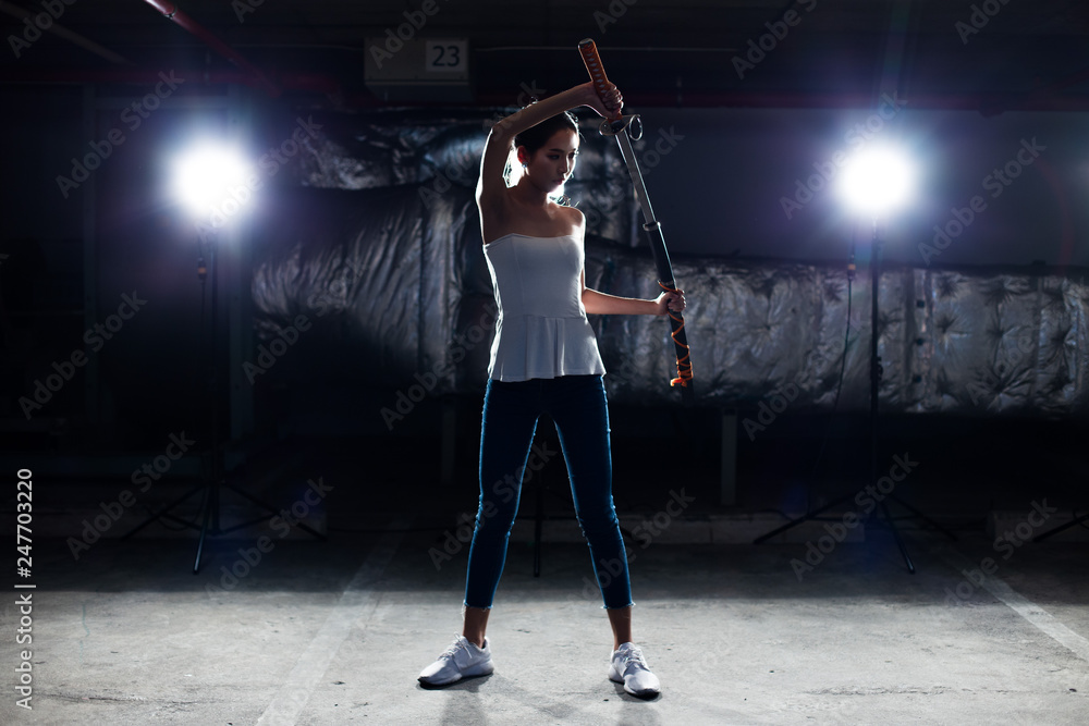 Beautiful Asian Woman demonstrates practice martial art Samurai blade ...