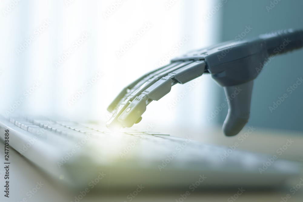 Robot with artificial intelligence is working on a computer. Robotic ...