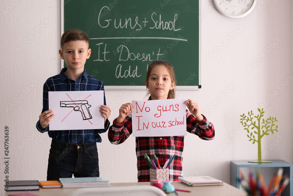 Cute little children with agitation posters in classroom. Concept of ...