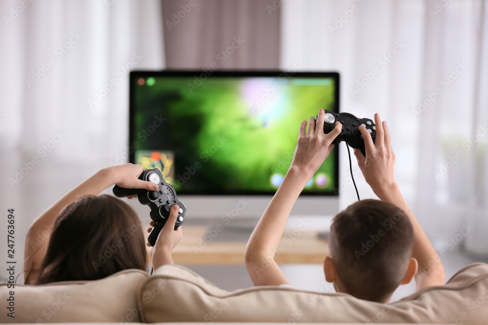 Cute little children playing computer game at home Stock Photo | Adobe ...