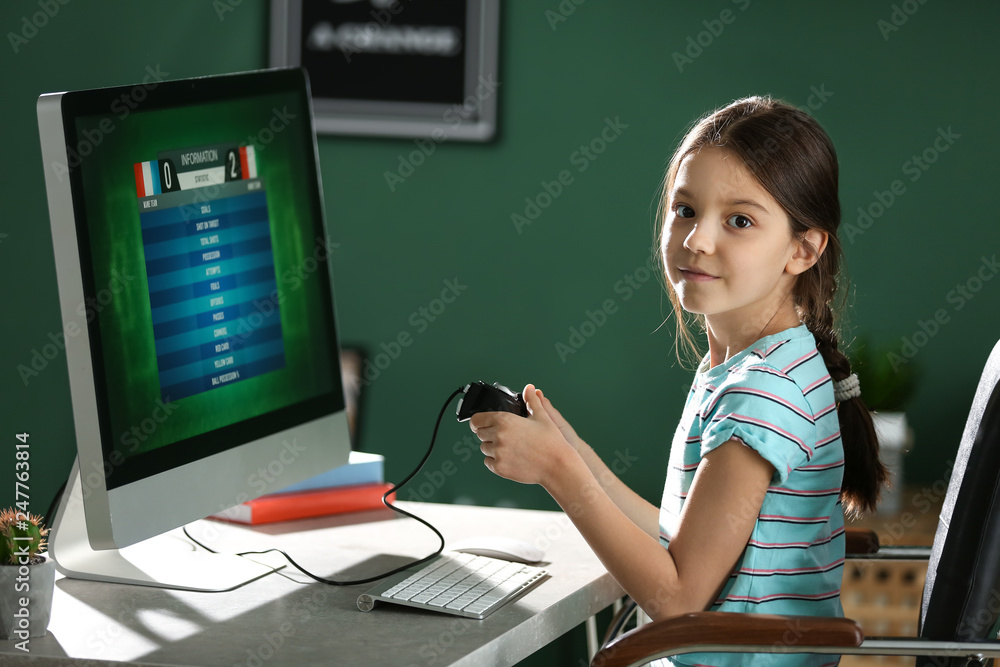 Cute little girl playing computer game at home Stock Photo | Adobe Stock