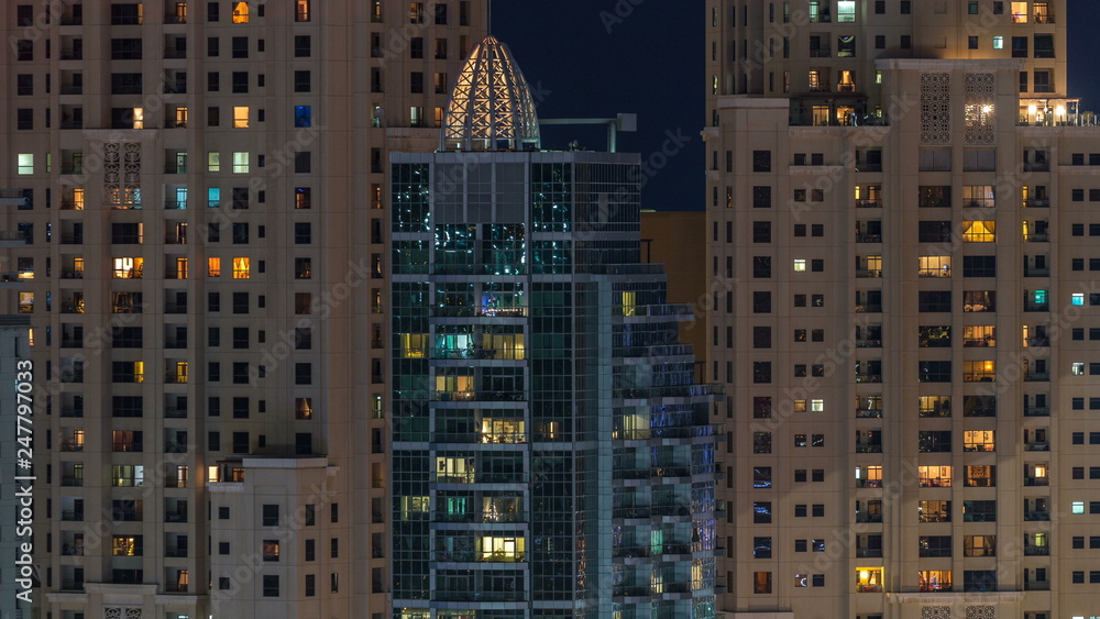 Glowing windows in multistory modern glass residential building light ...