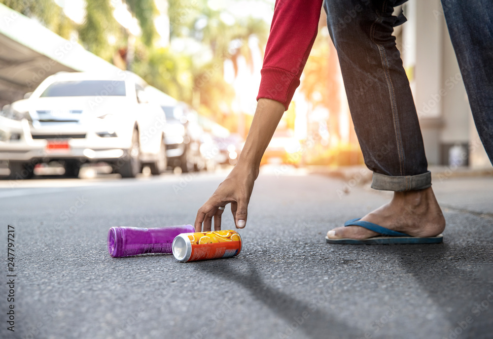 Photo of charity environment concept. Hand's man picking up Beverage cans on the street ground ...
