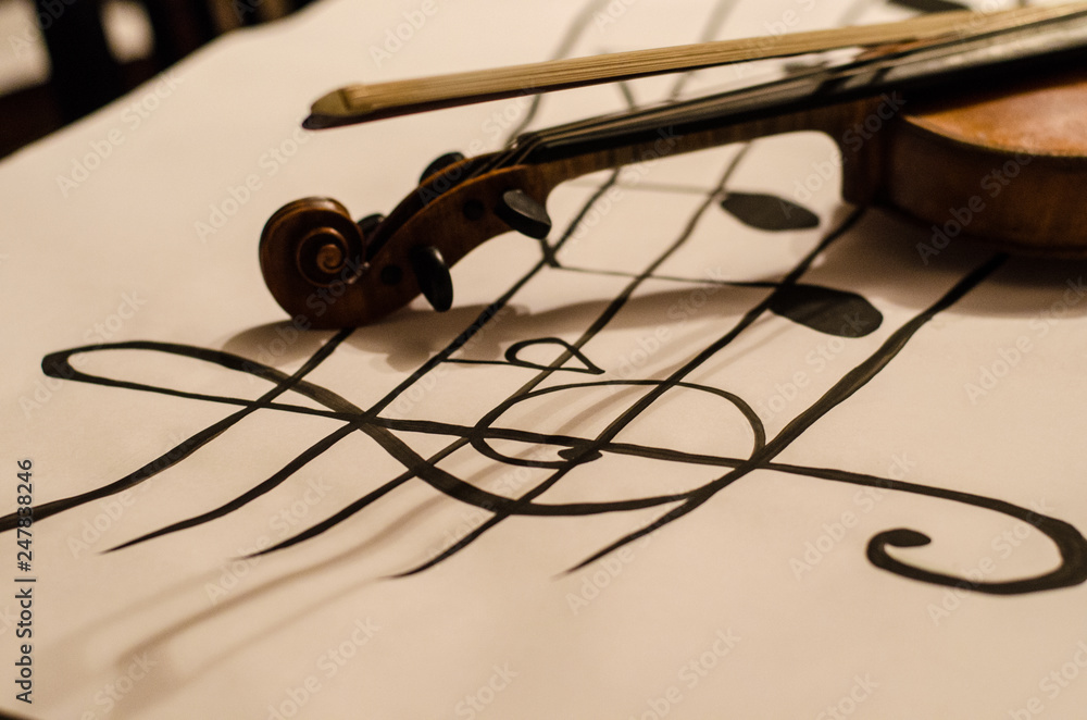 Close up of Violin handle with bow positioned in a diagonal over a ...