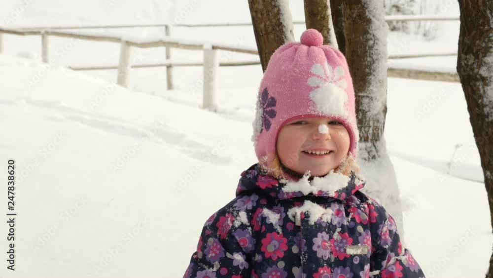 Smiling child face with snow on nose, kids playing with snow. Portrait ...