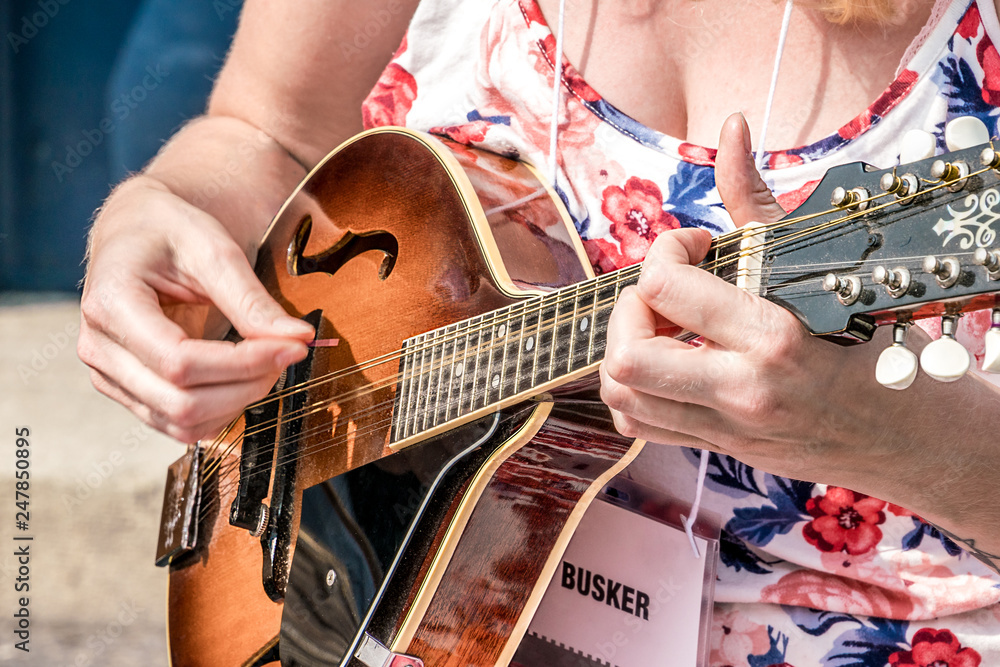 Female musician playing a mandolin, street performer, busker. Stock ...