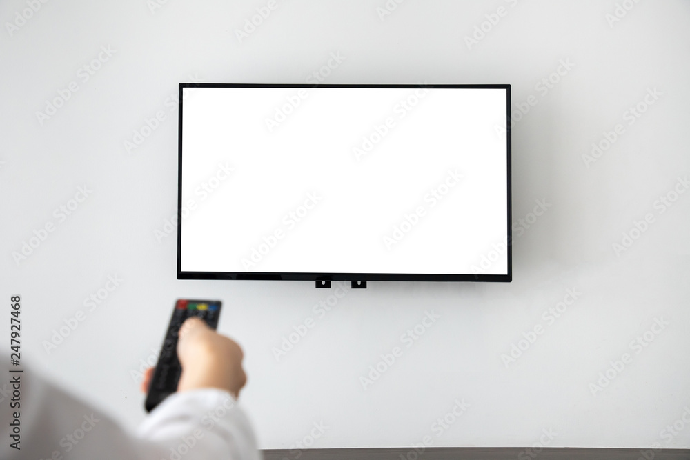 human hand pressing remote control with blank screen television on ...