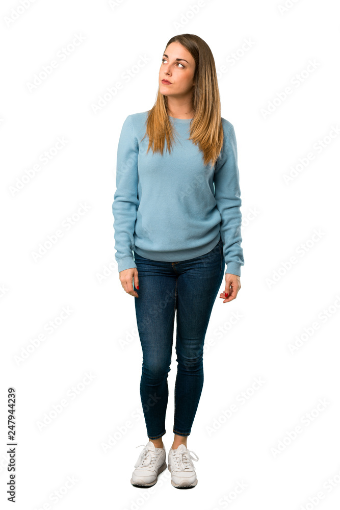 Full body of Blonde woman with blue shirt looking up with serious face ...