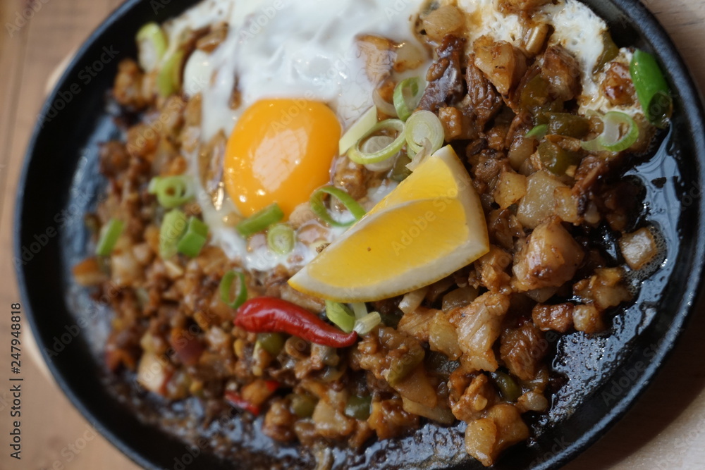 Pork sisig sizzling mince pork Filipino food with raw egg cooking hot ...
