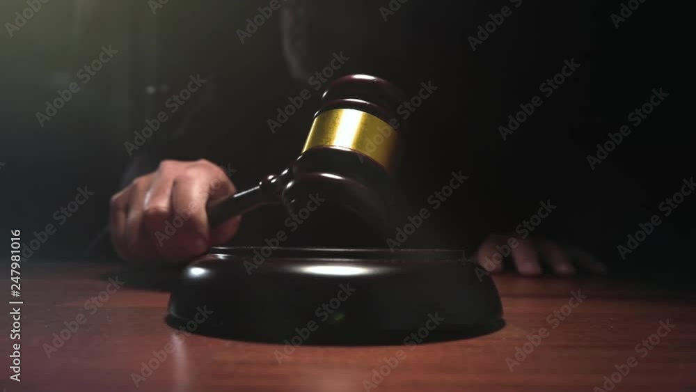 Judge hitting Gavel off a block in courtroom, dark background slow ...