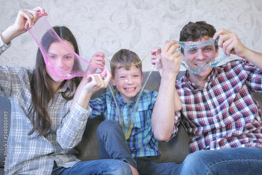 Happy family mom, son and dad and playing with slimes sitting on the ...