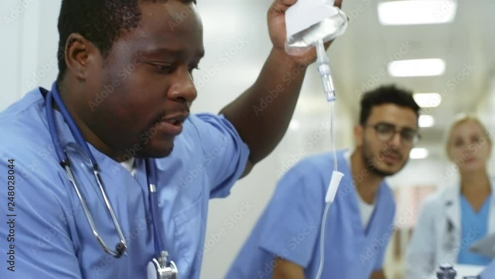 Dolly shot of emergency room male nurses administering oxygen and IV ...