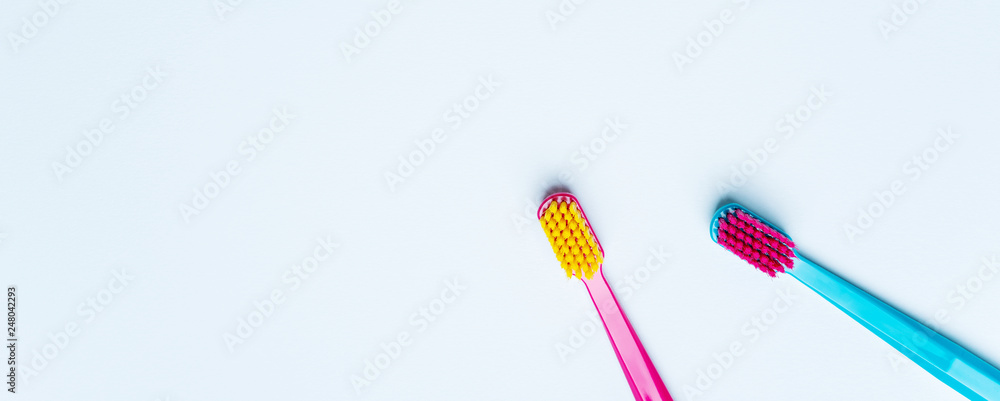 Colorful tooth brushes with bright color bristles on a light pastel ...