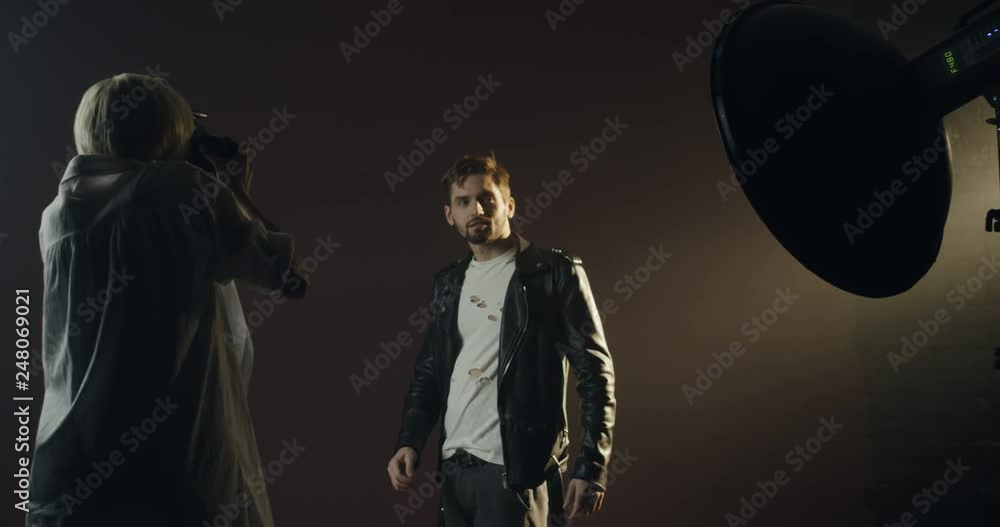 Back view of the female photographer making photoshoot for the male ...