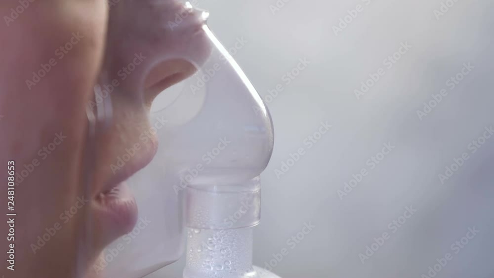 Use nebulizer and inhaler for the treatment. Young woman inhaling ...