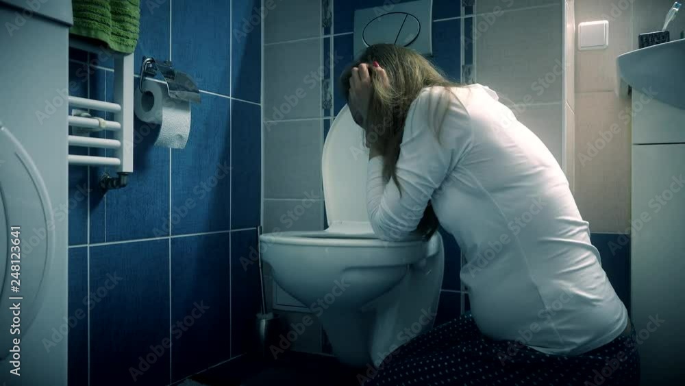 Young woman vomiting in bathroom wc - morning sickness during pregnancy ...