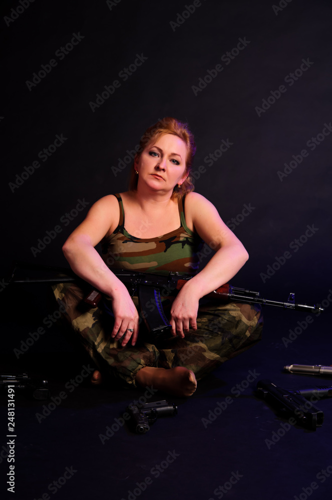 Foto de A middle aged, white, woman holds an AK47 automatic rifle, with ...