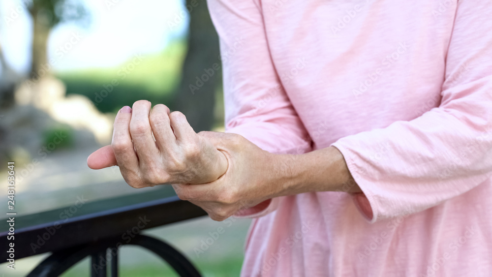 Old woman stretching numb arm, weakness of muscles in senior age ...