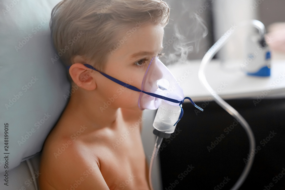 sick boy in nebulizer mask making inhalation, respiratory procedure by ...