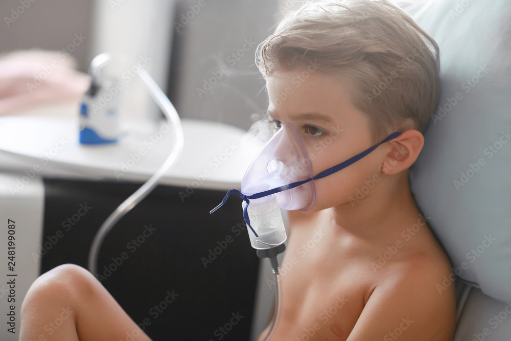 sick boy in nebulizer mask making inhalation, respiratory procedure by ...