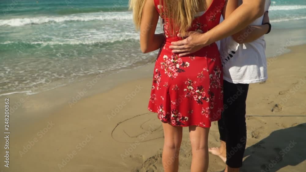Young couple standing at the beach admiring beautiful seascape, Man and ...