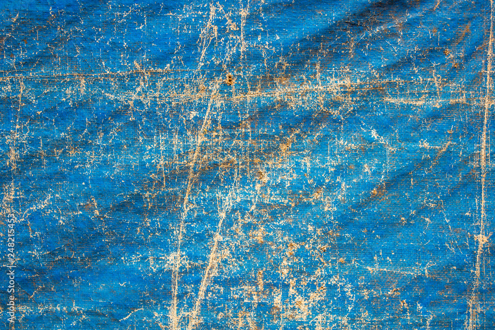 old shabby blue canvas with folds and holes close up. rough surface ...