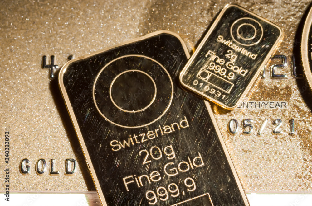 999.9 gold bars and a fragment of a gold coin on a background of a gold ...