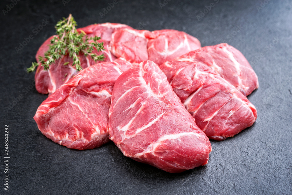 Traditional German raw pork cheeks with hers as closeup on a black ...
