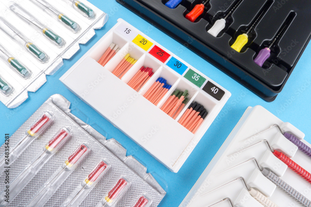 Endodontic instruments. Set of dental instruments on blue. Endodontic ...