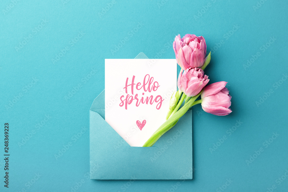 Three pink tulips in turquoise envelope on turquoise background with ...