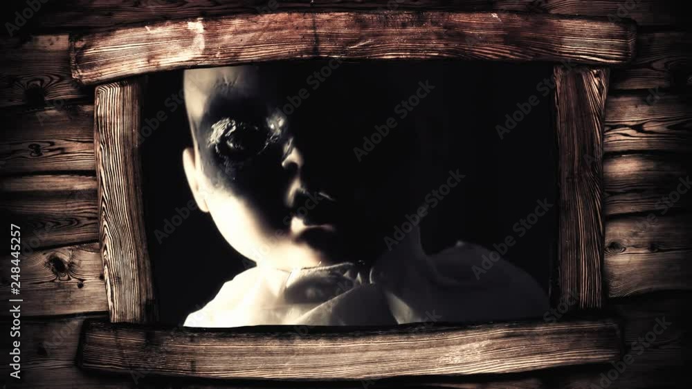 Seen from the window of a wooden cabin: a haunted doll, covered with ...