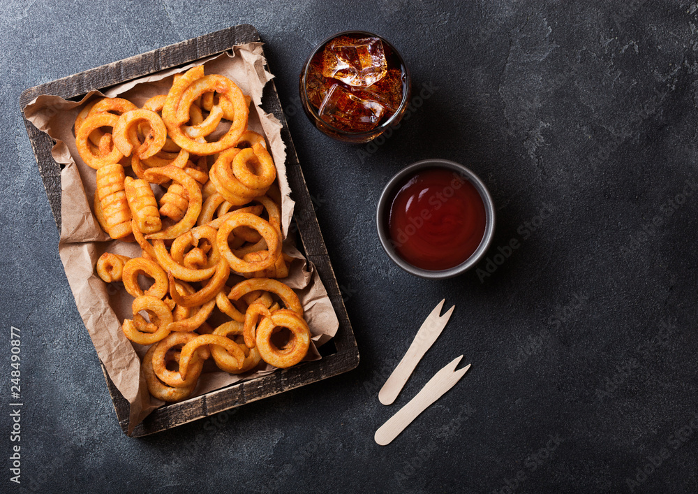 Curly fries fast food snack in wooden with ketchup and glass of cola on ...