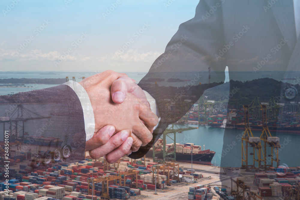 Double exposure of business partner handshake and Container ship in ...