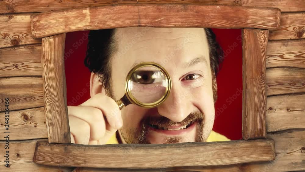 Seen from the window of a wooden cabin: a funny ugly man looking at the ...