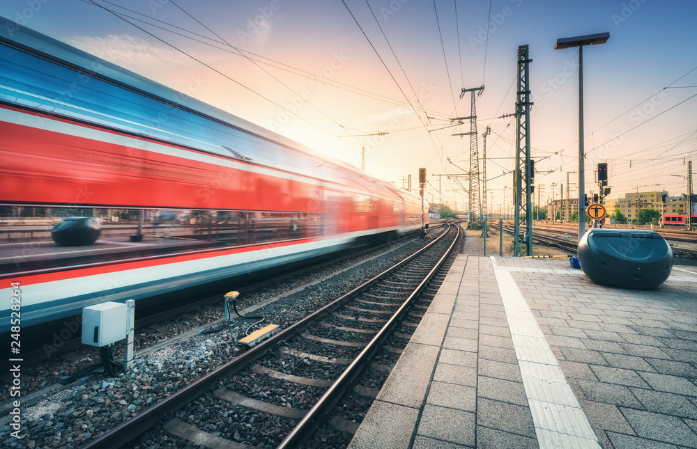 Red high speed train in motion on the railway station at colorful ...