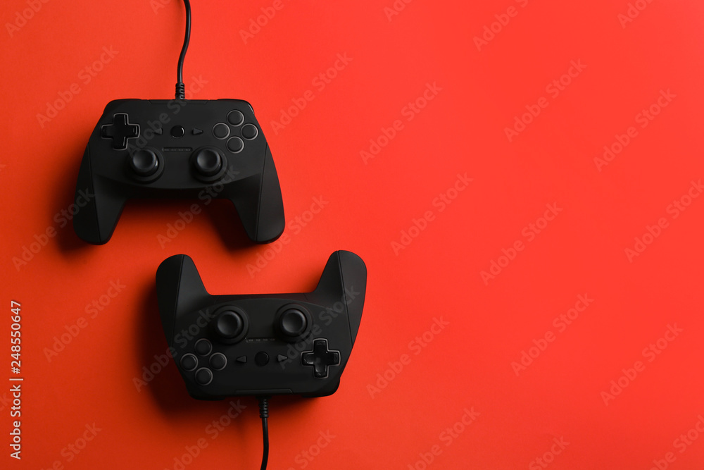 Modern video game controllers on color background, top view with space ...
