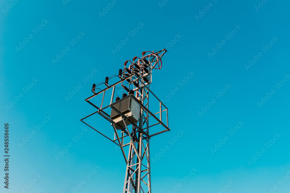 High voltage power transformer or power substation tower with blue ...