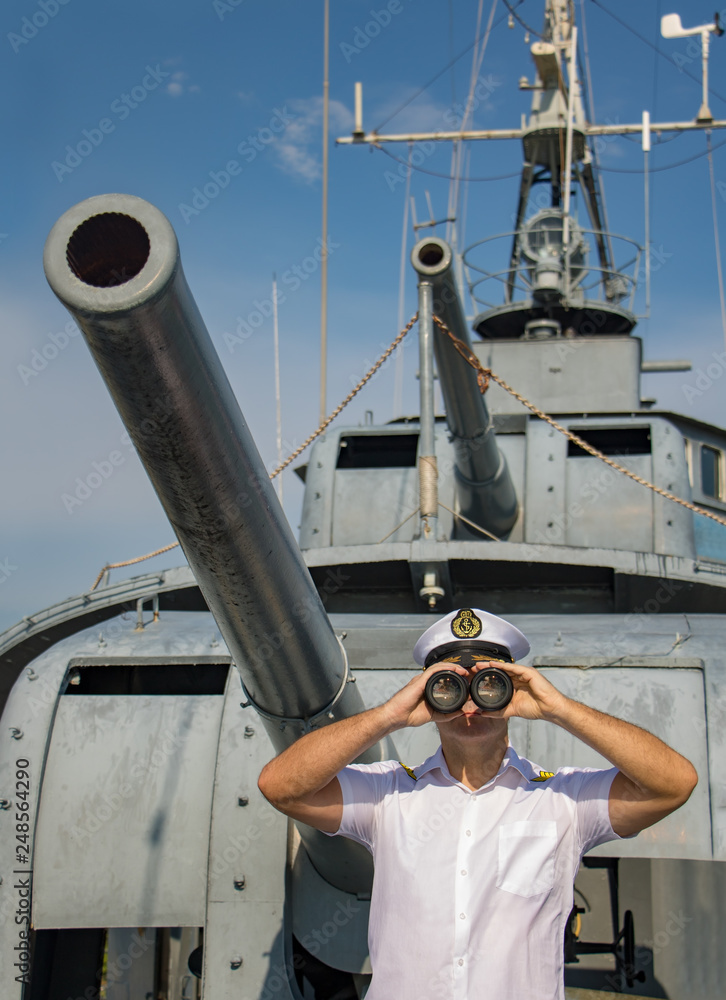 Captain of warship standing beside cannons and looking ahead. A navy ...