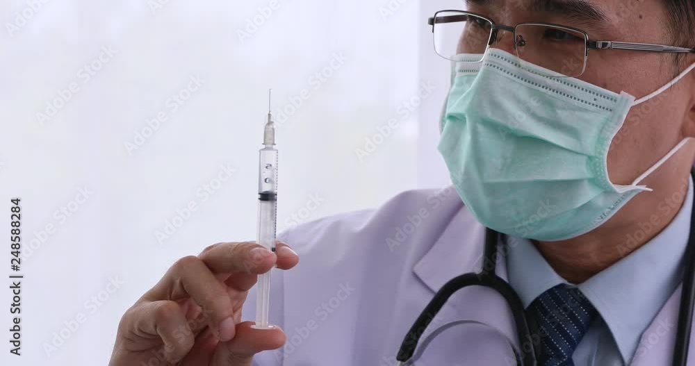 Close up scene video of Asian doctor holding syringe and talking to ...