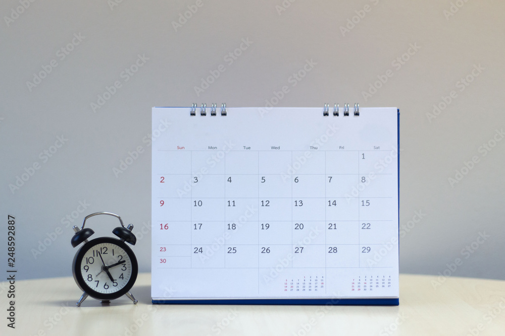Calendar with alarm clock on desk table - Time management concept ...