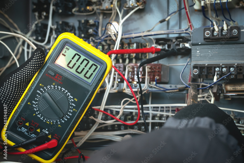 Electrician is checking the voltage in the electrical circuit of the ...