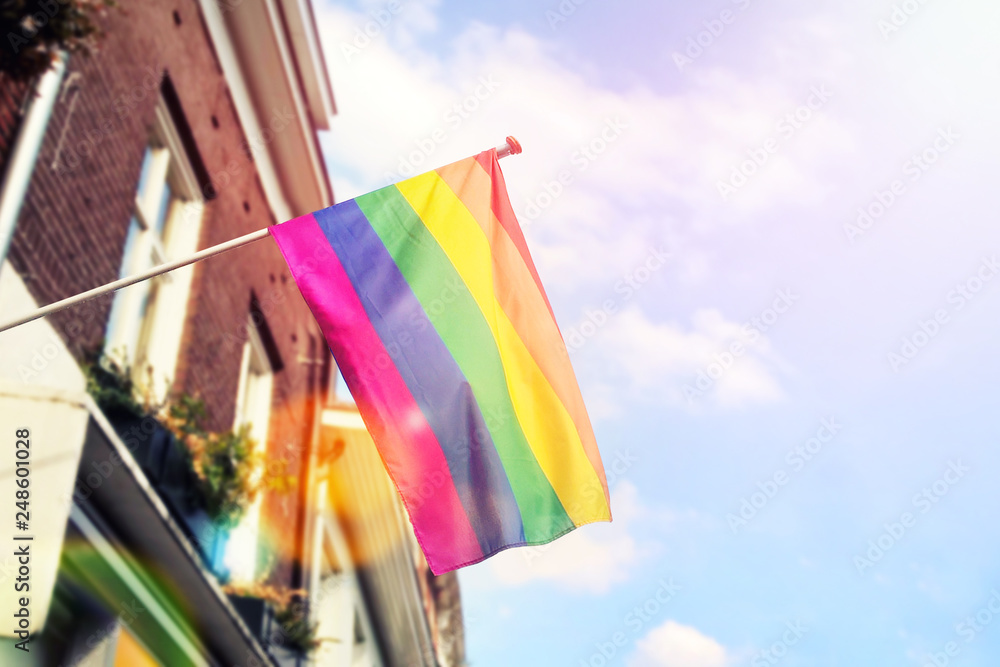 Rainbow LGBT flag against the blue sky, symbol of tolerance and ...